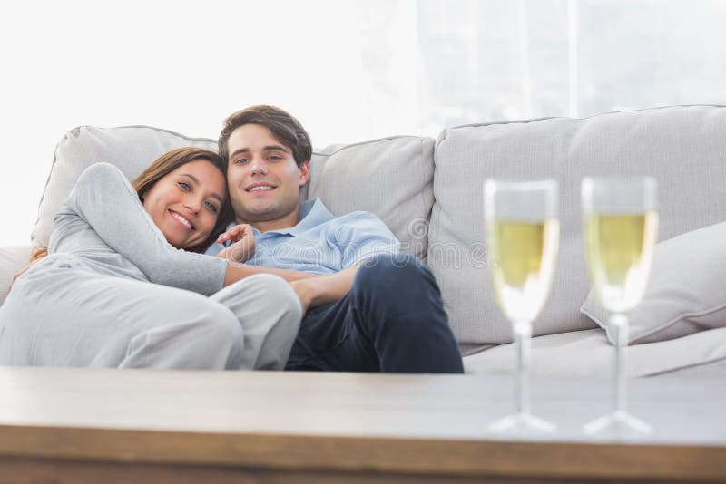 Beautiful Couple Resting on a Couch with Flutes of Champagne Stock ...
