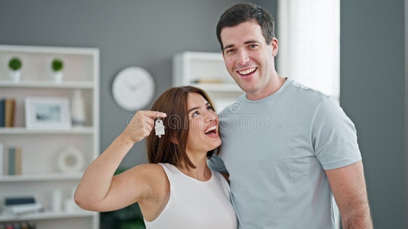 Beautiful Couple Standing Hugging Each Other Holding Keys Of New Home