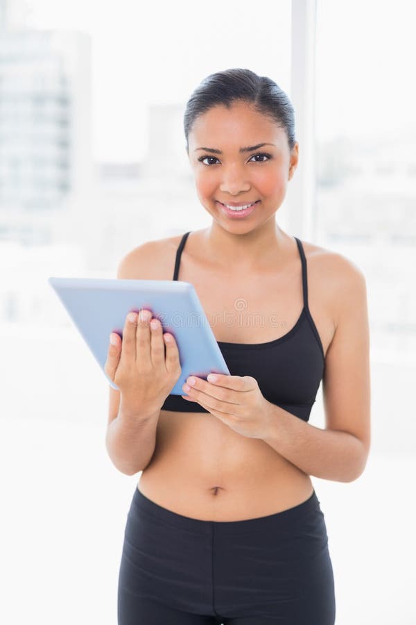 Beautiful Dark Haired Model In Sportswear Holding A Tablet Pc Stock