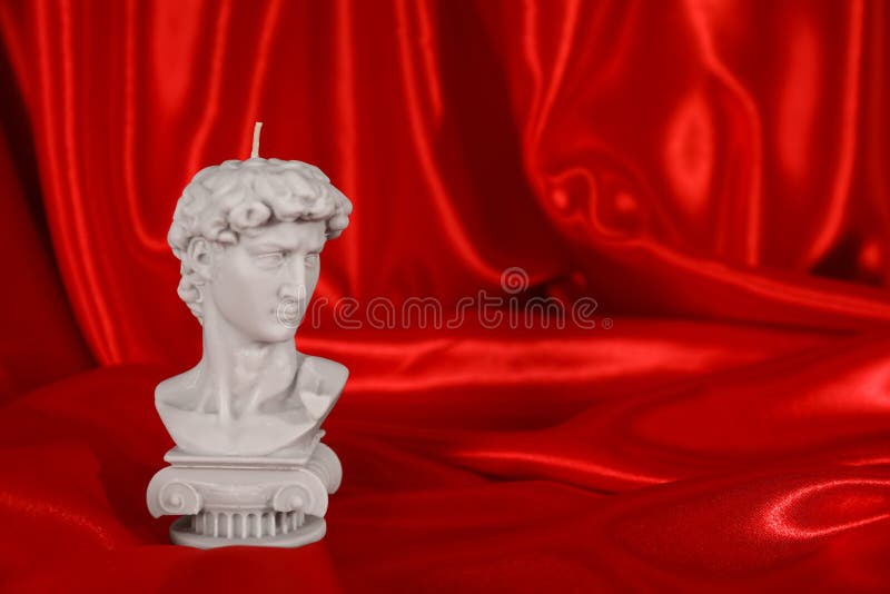 Beautiful David Bust Candle on Red Satin. Space for Text Stock Photo ...