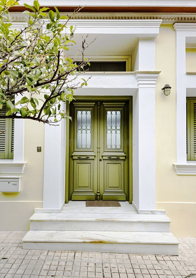 Beautiful Entrance with Green Doors and Decorative Tree in Front of a ...