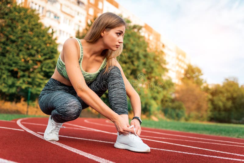 Beautiful Female Runner Tying Shoelaces in the Running Track. Stock ...