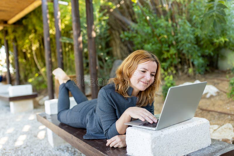 A Beautiful Freelancer Woman Works at the Park Using a Computer Stock ...
