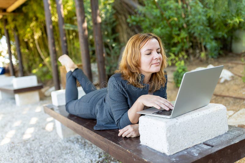A Beautiful Freelancer Woman Works at the Park Using a Computer Stock ...