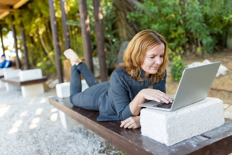 A Beautiful Freelancer Woman Works at the Park Using a Computer Stock ...