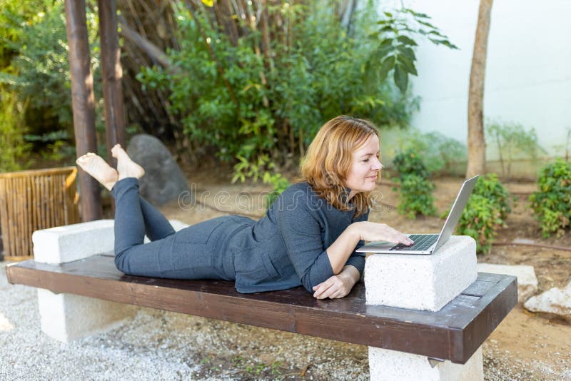 A Beautiful Freelancer Woman Works at the Park Using a Computer Stock ...