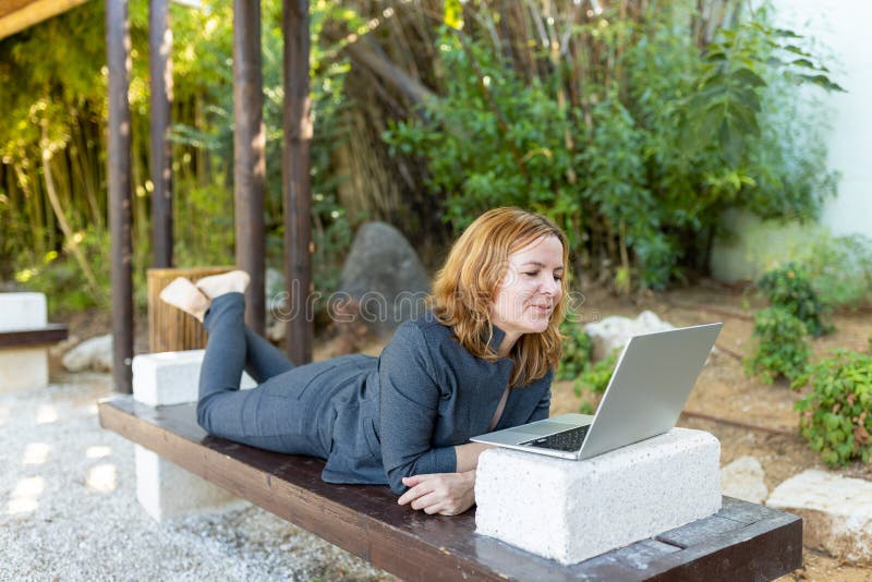 A Beautiful Freelancer Woman Works at the Park Using a Computer Stock ...