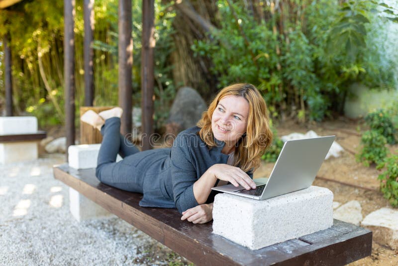 A Beautiful Freelancer Woman Works at the Park Using a Computer Stock ...