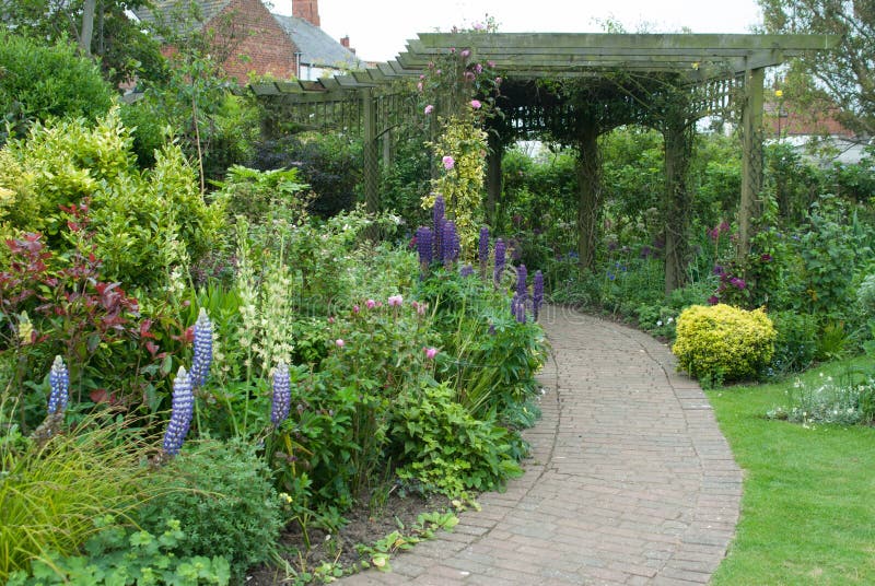 Beautiful Garden Pathway Lined with Vibrant Flowers and Greenery in a ...