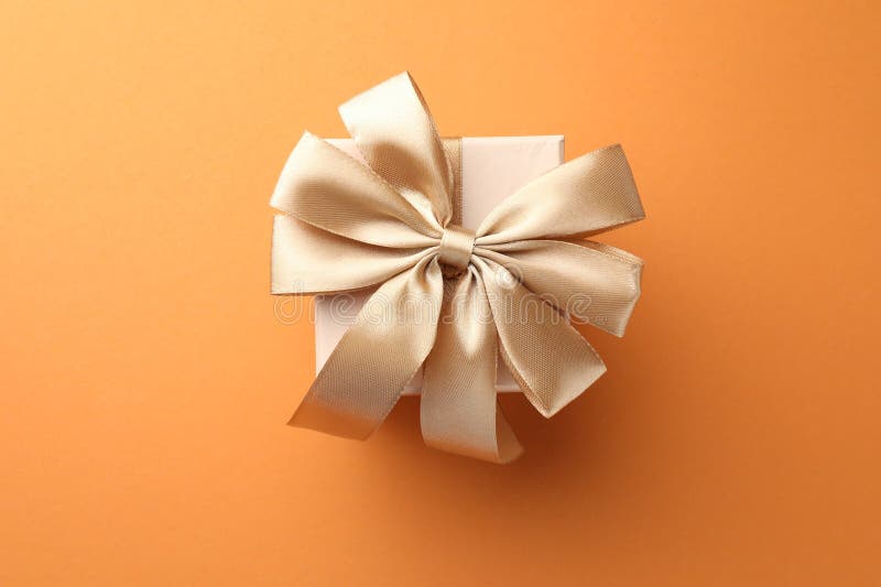 Beautiful Gift Box with Golden Bow on Orange Background, Top View Stock ...
