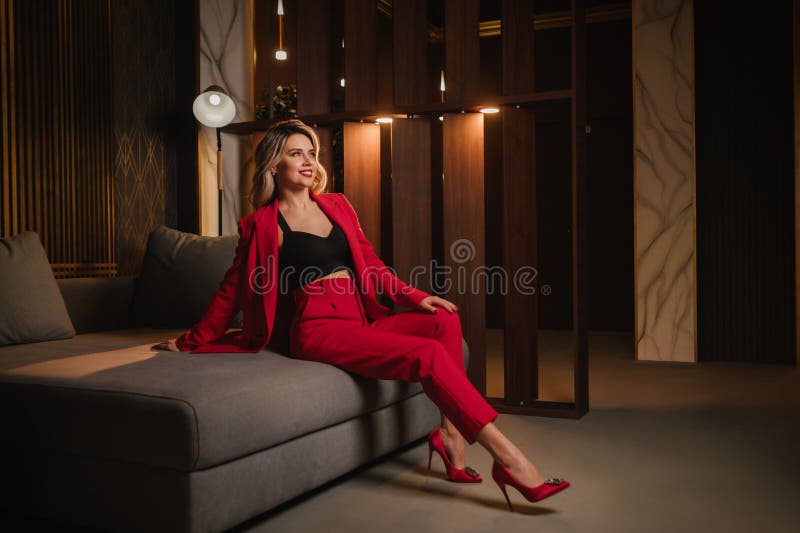 A Beautiful Girl Dressed in a Red Formal Suit Posing in a Modern ...