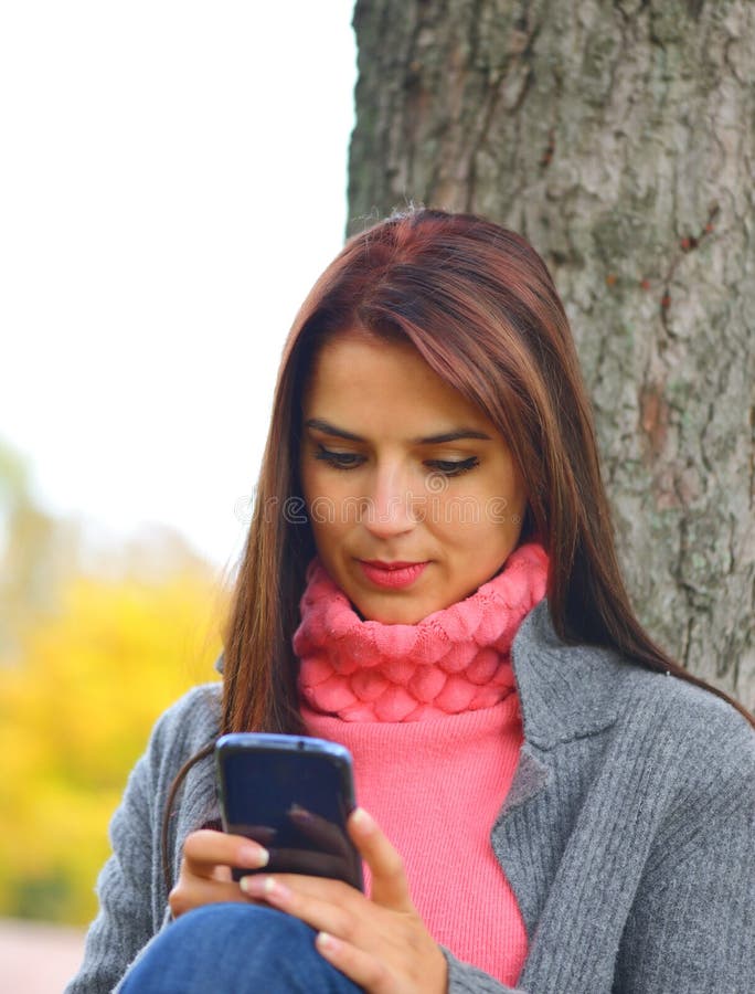 Beautiful Girl Messaging with Phone in Park Stock Photo - Image of ...