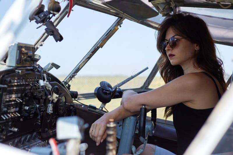 A Beautiful Girl Pilot is in the Cockpit of the Aircraft at the Helm ...