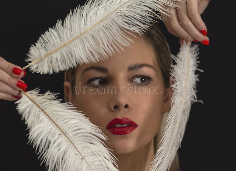Beautiful Girl Posing with a Large White Feather on a Dark Background ...