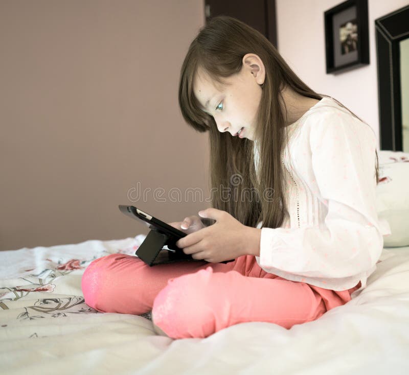 Beautiful Girl Lies on a Bed and Playing Computer Game Stock Photo ...
