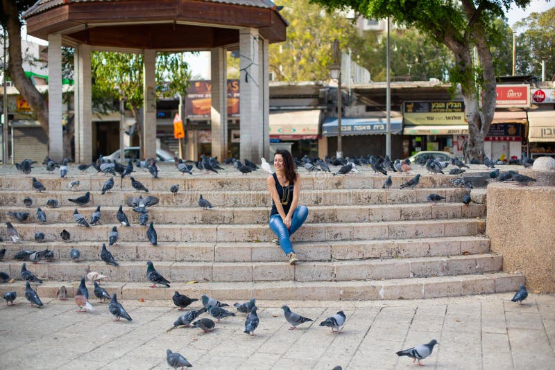 A Beautiful Girl is Sitting on the Steps in the Park Surrounded by ...