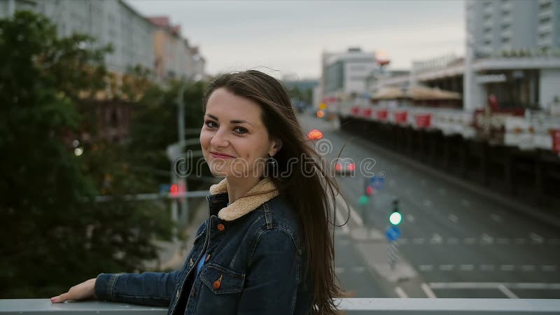 Beautiful Girl Standing On Bridge Looks At City Then Turns To The