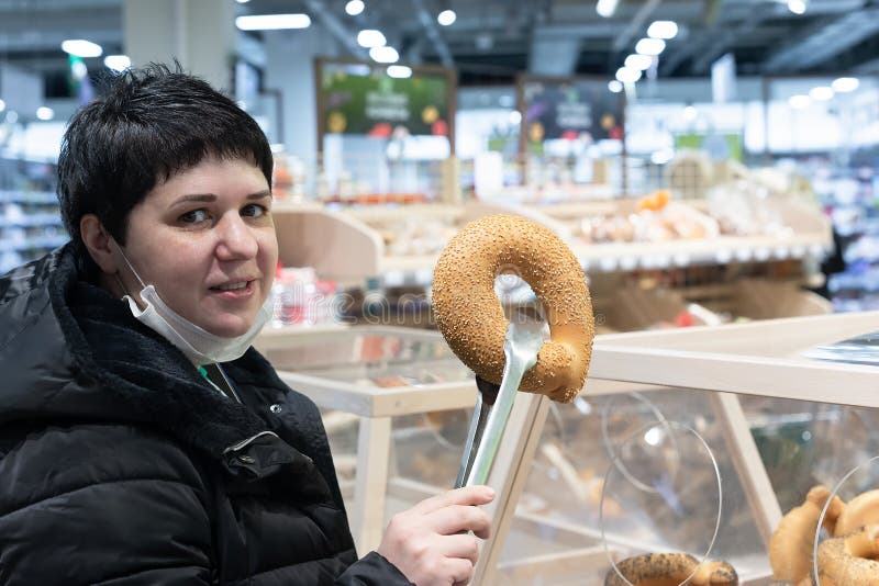 A Beautiful Girl in the Store with Bread in Her Hands Stock Photo ...