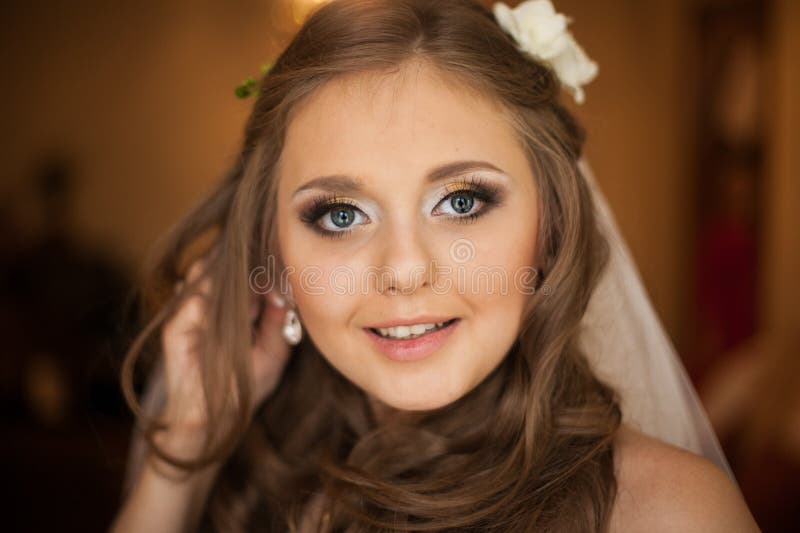 Beautiful Gorgeous Brunette Bride Putting On Luxury Earrings In Stock