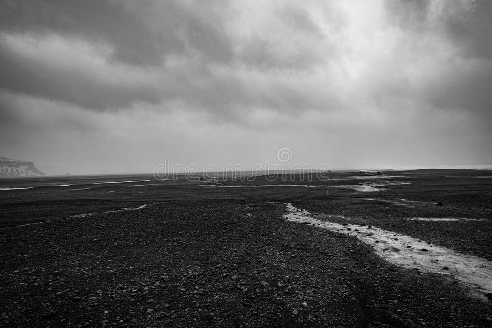 Grayscale Shot of the Beach Shore Under a Cloudy Sky Stock Photo ...