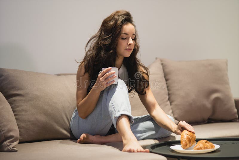Beautiful Happy Lady In Casual Clothes Sitting On Couch Indoors Holding