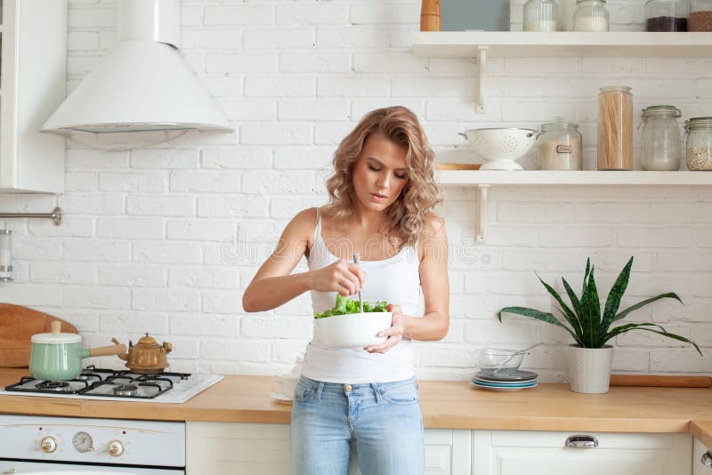 Beautiful Healthy Casual Woman Preparing Vegetable Salad In Her Kitchen