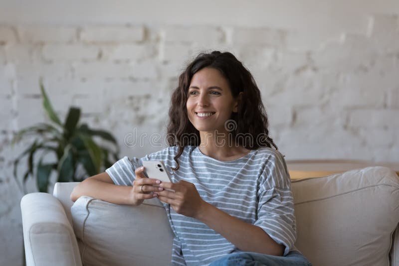 Beautiful Hispanic Woman Sit on Sofa Holding Modern Smartphone Stock ...