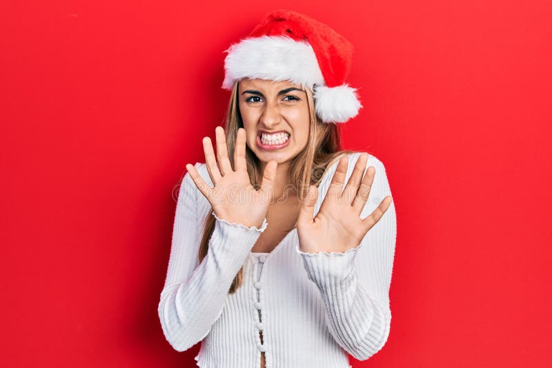 Beautiful Hispanic Woman Wearing Christmas Hat Afraid And Terrified