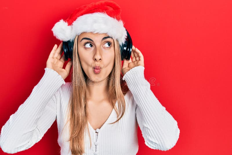 Beautiful Hispanic Woman Wearing Christmas Hat And Headphones Making