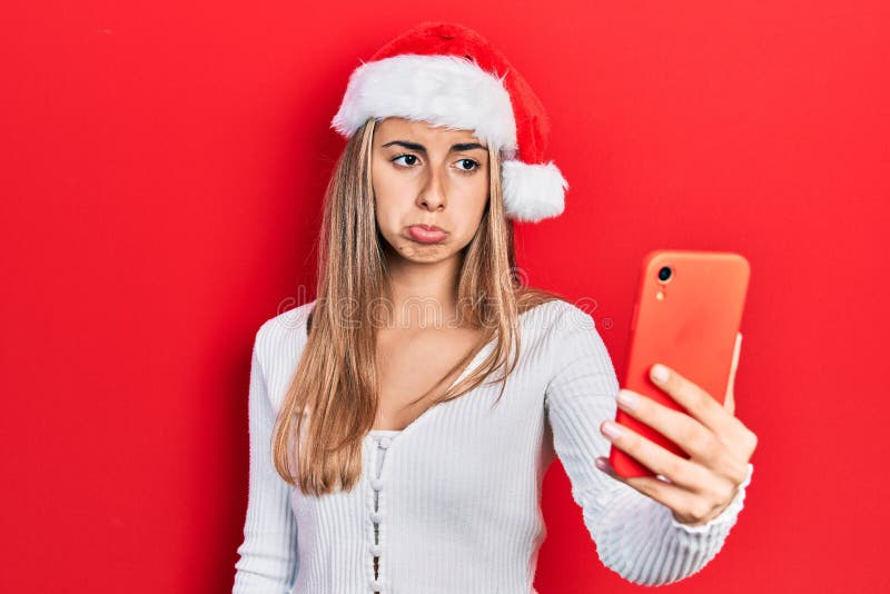 Beautiful Hispanic Woman Wearing Christmas Hat Using Smartphone
