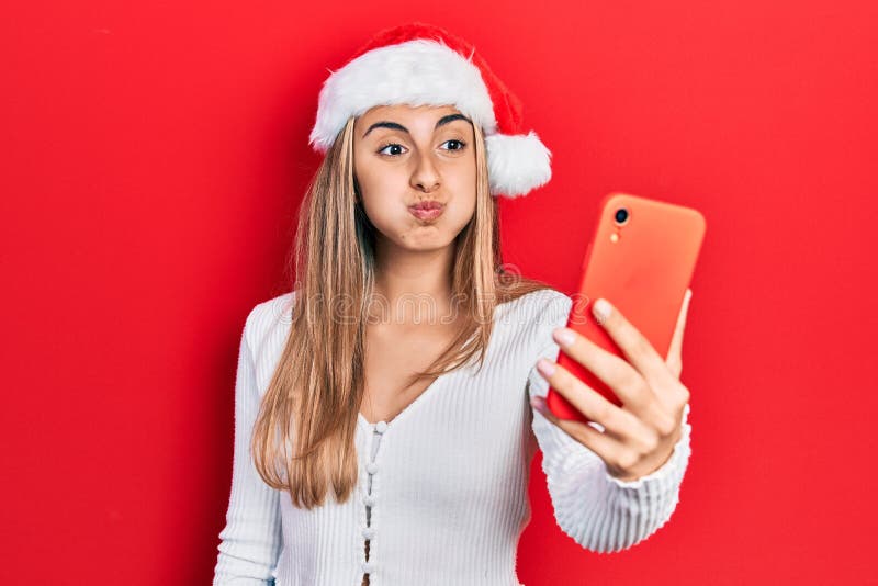 Beautiful Hispanic Woman Wearing Christmas Hat Using Smartphone Puffing