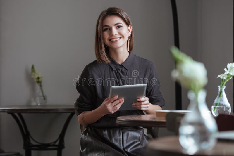 Beautiful Lady Sitting Near Window while Using Tablet Computer. Stock ...