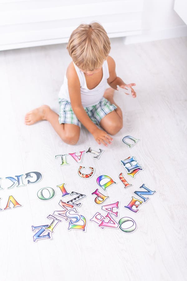 Beautiful Little Boy Learning Letters on the Floor at Home Stock Photo ...