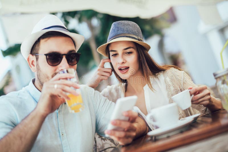 Loving Couple Sitting in a Cafe Enjoying in Coffee and Using Phone ...