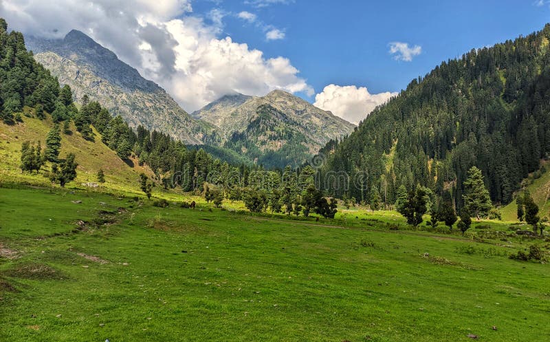 A Beautiful Meadow Surrounded with Mountains. Stock Image - Image of ...