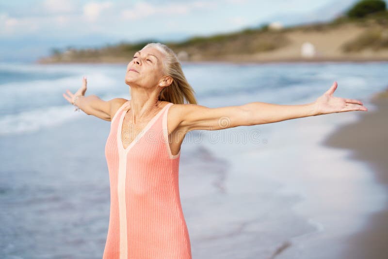 Beautiful Older Female Spreading Her Arms On A Beautiful Beach