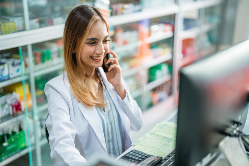 Beautiful Pharmacist Working in Front of Computer Monitor while Calling ...