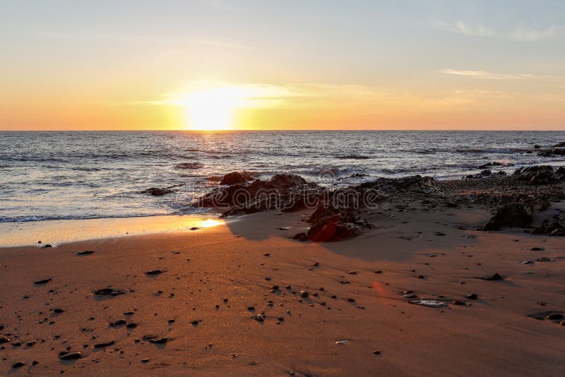 Beautiful Quiet and Calm Beach during an Orange Sunset Stock Photo ...