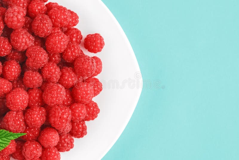 Beautiful Raspberry in a White Plate Top View, Blue Background Stock ...
