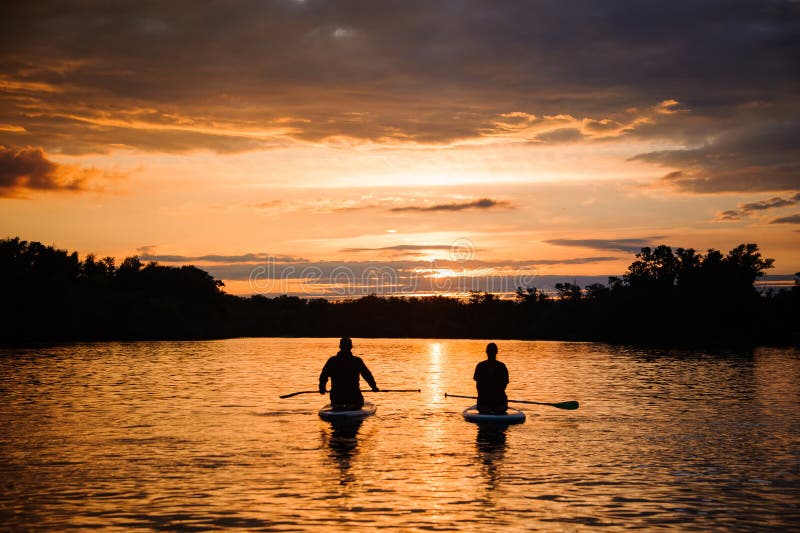 Beautiful Rear View of Two Sitting People on Sup Boards Which Floating ...