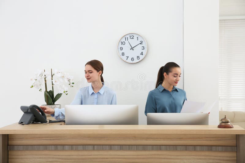 Beautiful Receptionists Working at Counter in Hotel Stock Image - Image ...