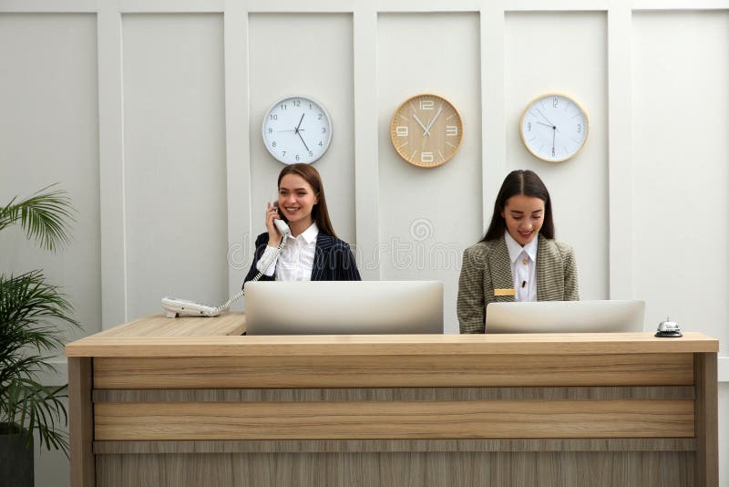 Beautiful Receptionists Working at Counter in Hotel Stock Photo - Image ...
