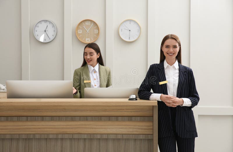 Beautiful Receptionists Working at Counter in Hotel Stock Image - Image ...