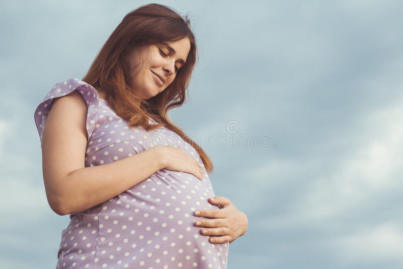 Beautiful Red Haired Pregnant Woman Use Tape Measure At Big Belly On