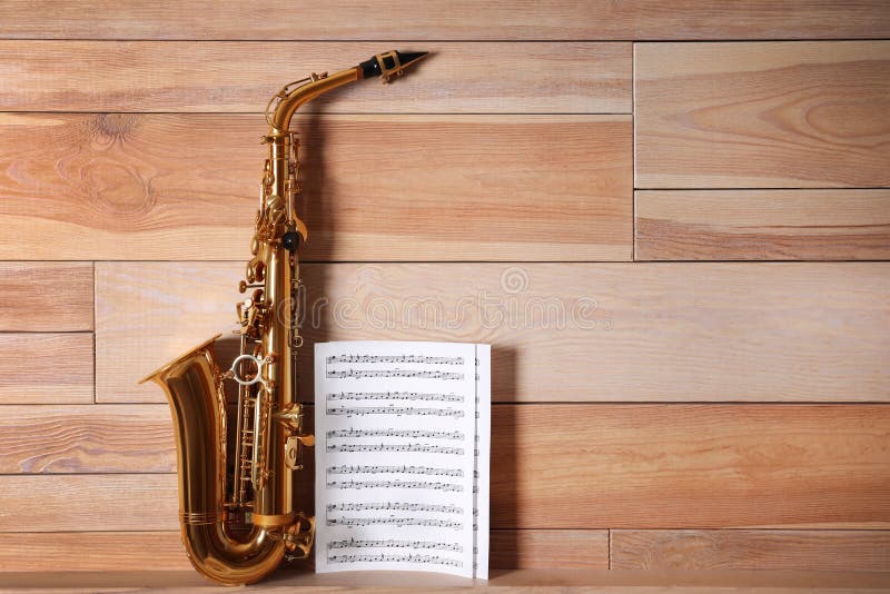 Beautiful Saxophone and Note Sheets on Table Near Wall, Space for Text ...