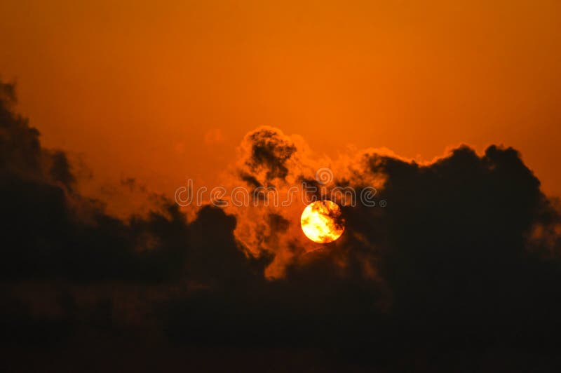 A Beautiful Scene of the Sun through Huge Black Clouds. Stock Photo ...