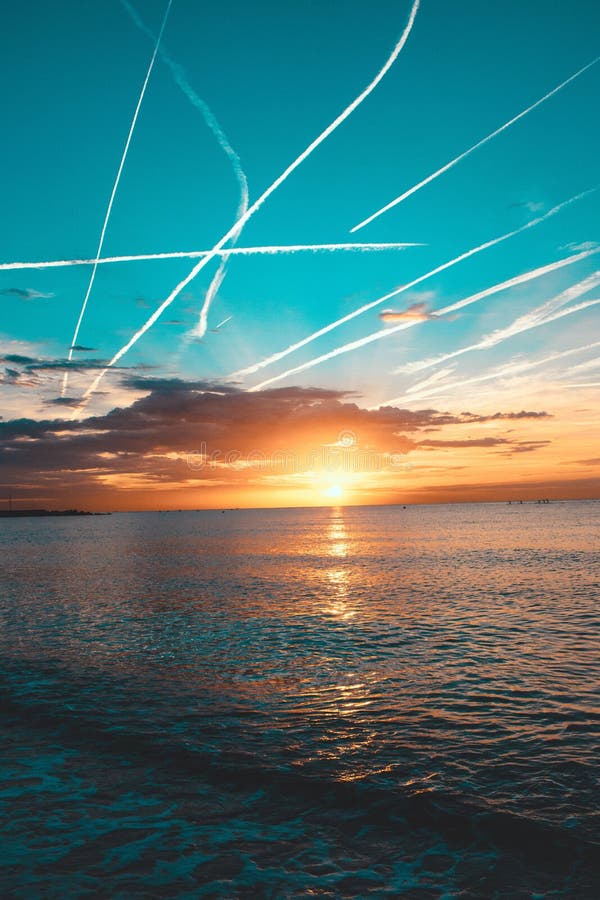 Beautiful Scene of Waves by the Beach Under Orange Sky on the Horizon ...