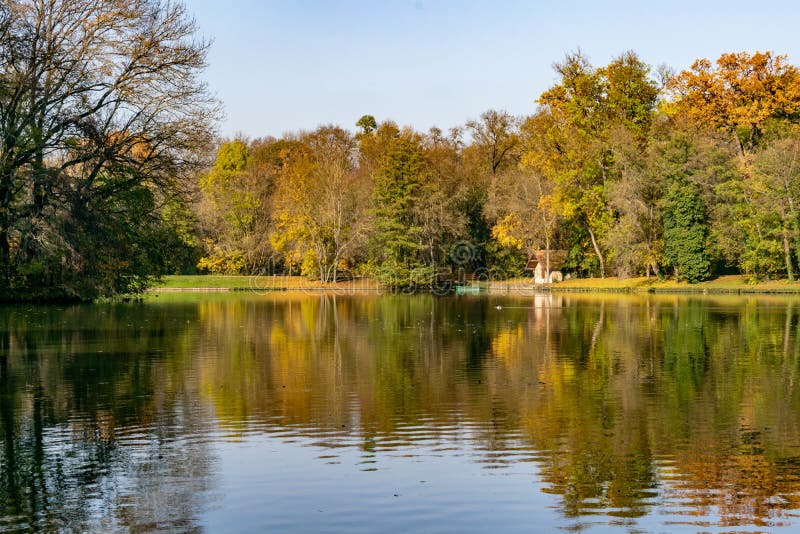 Beautiful Scenery of a Reflective Lake Surrounded by Trees and Greenery ...