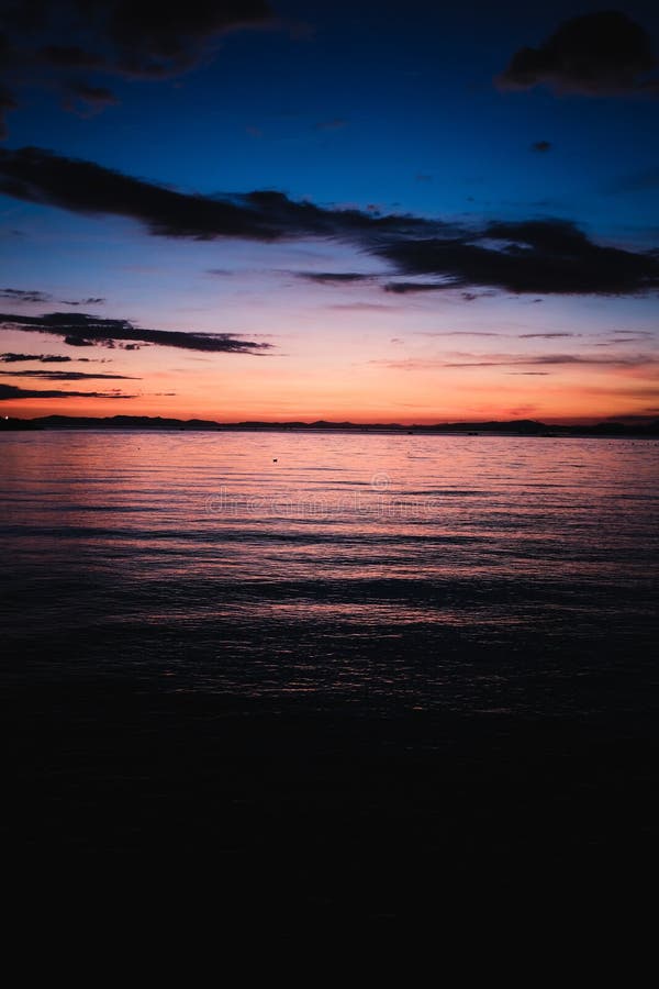 Beautiful Scenery of the Sea at Sunset with Dark Clouds and Reflection ...