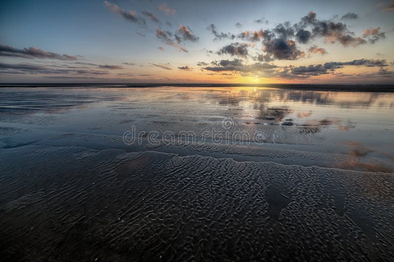 Beautiful Scenery of the Sunset Reflected in a Mudflat Under the Cloudy ...